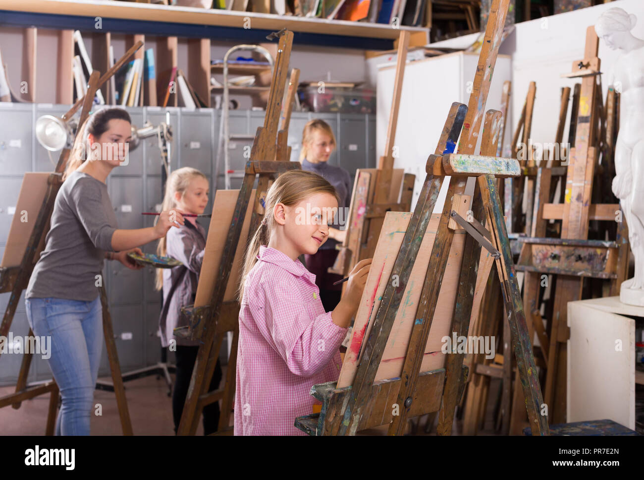 happy russian schoolgirls diligently training their painting skills ...
