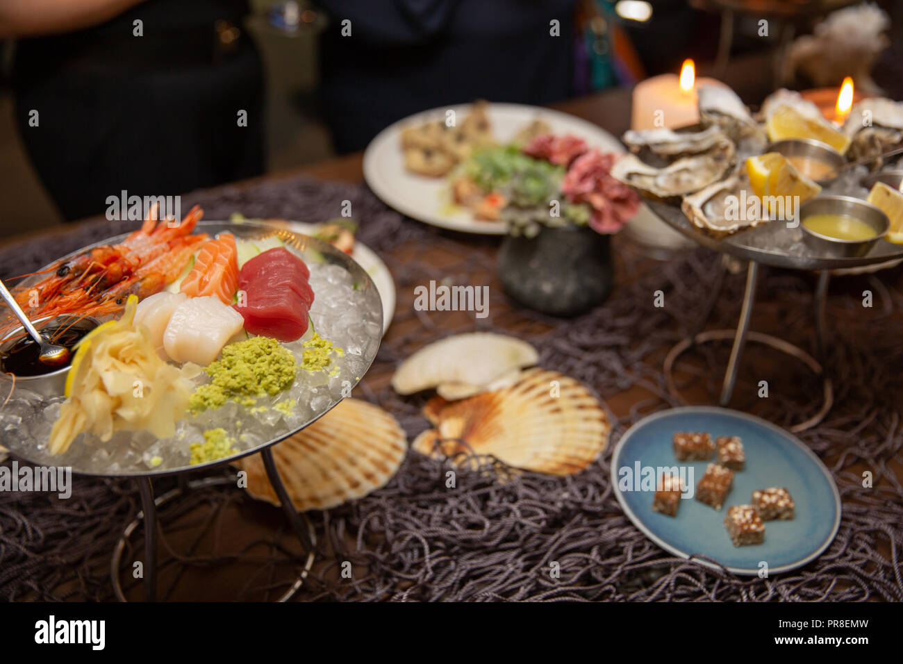 Mixed sliced fish sashimi and shrimps on ice in black bowl. Sashimi ...