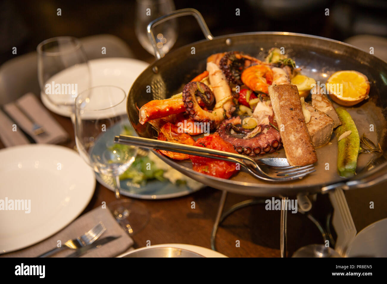 sea cocktail in a black plate. shrimp mussels, octopus, tuna, squid and ...