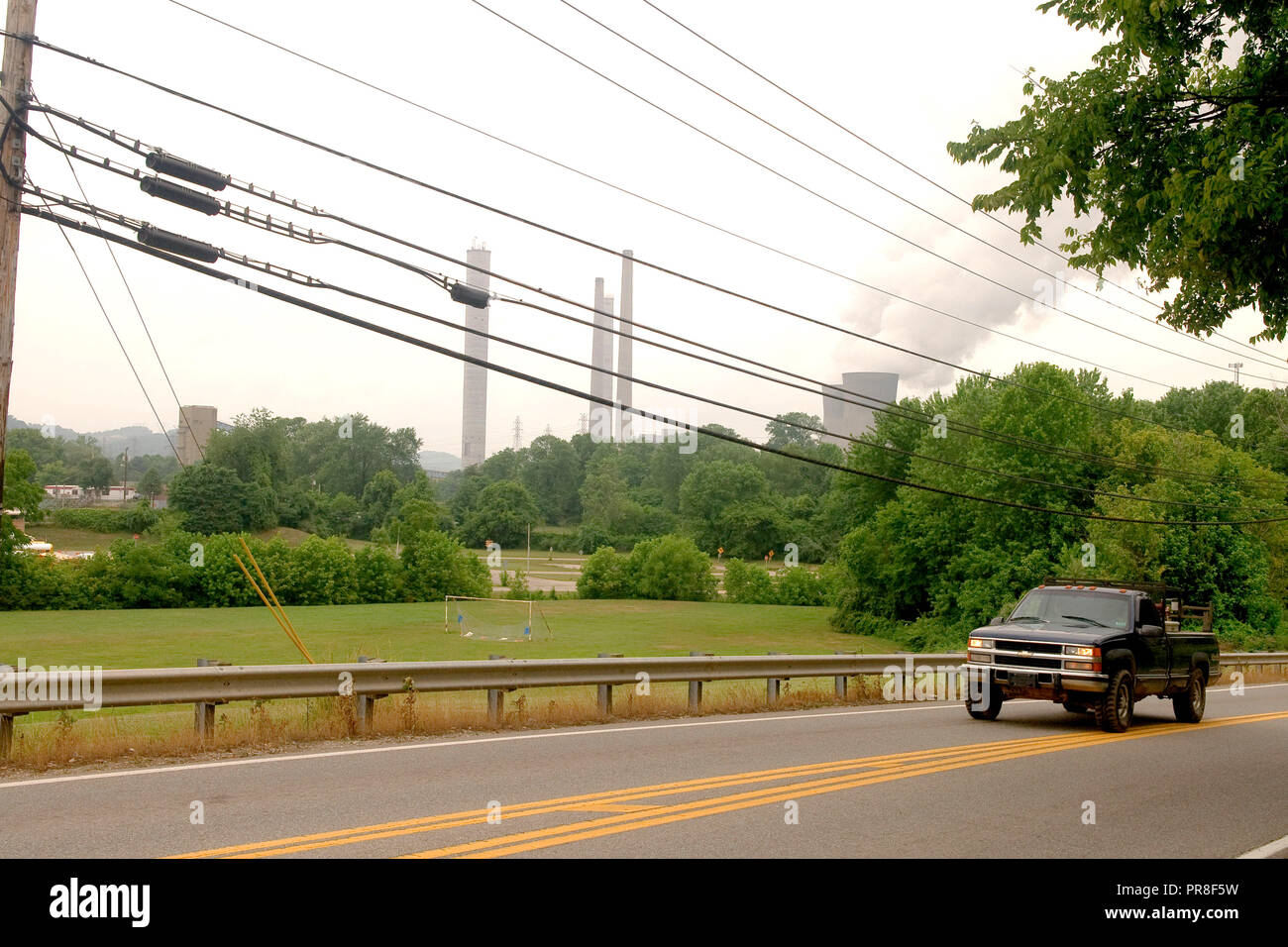 2007 - Pick up truck driving down road with power plant cooling tower ...