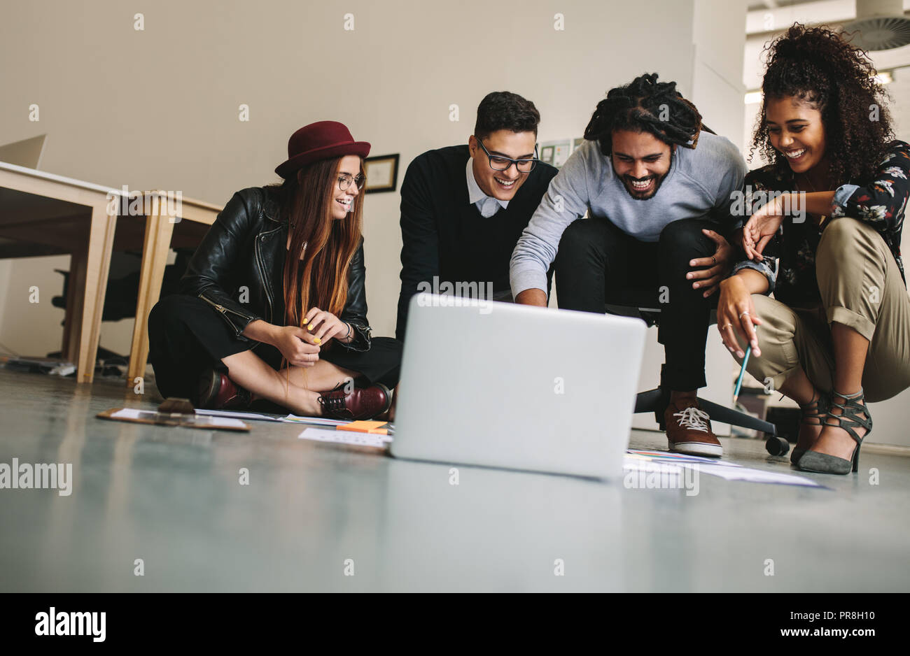 business partners sharing ideas sitting on the floor with laptop and ...
