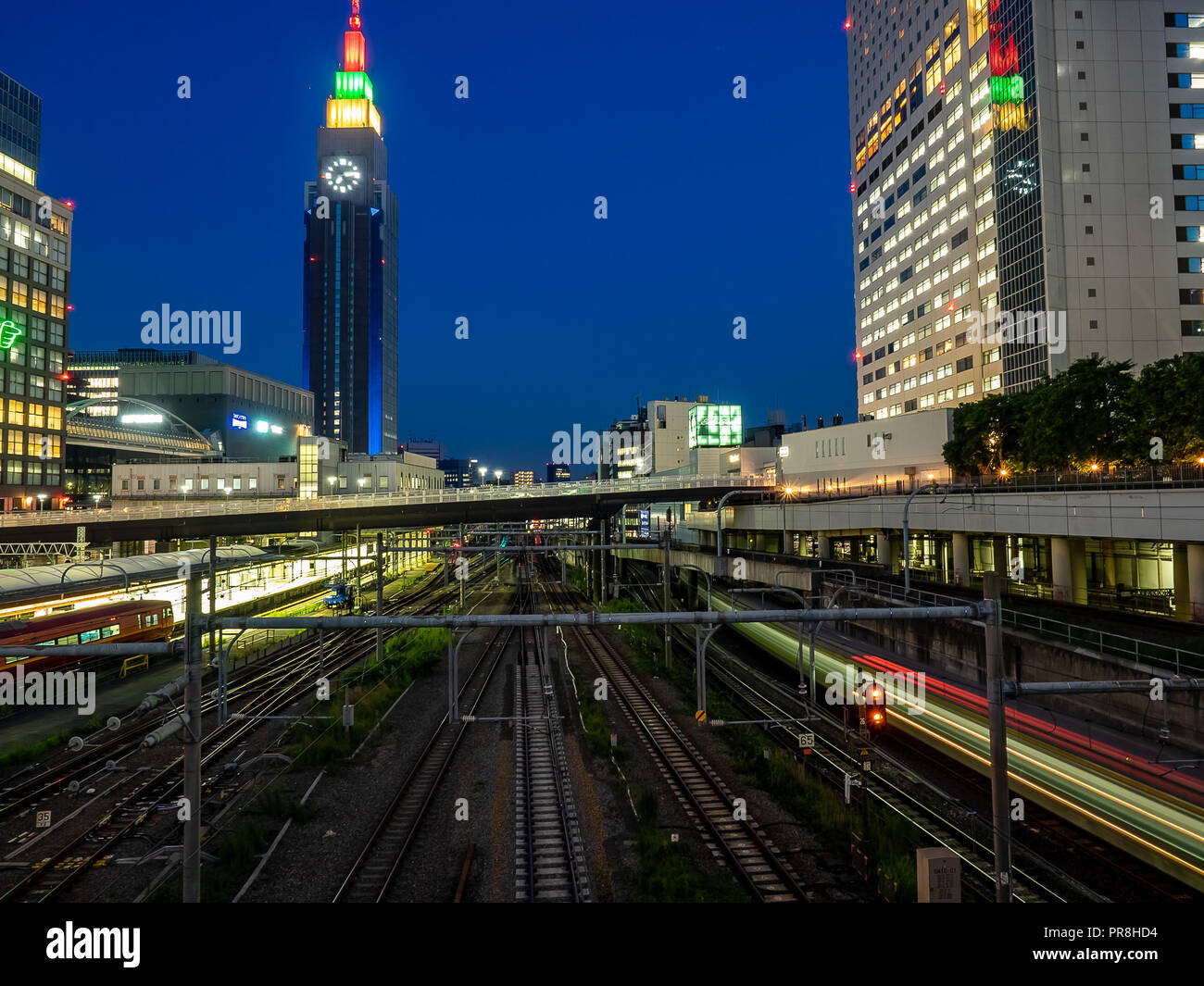 Train tracks run through Shinjuku, Tokyo at night, as seen from the ...