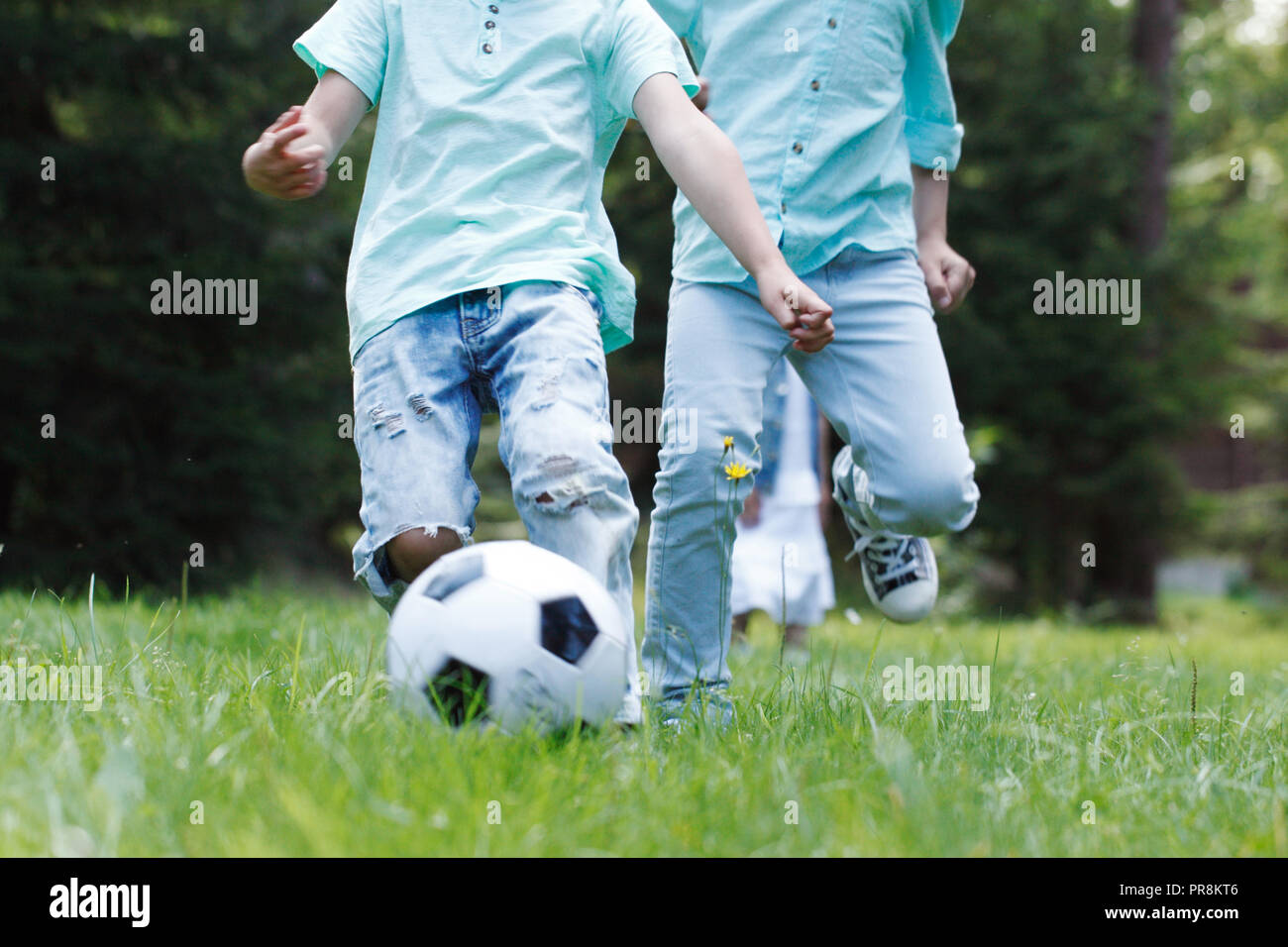 Happy children playing football in summer park Stock Photo - Alamy