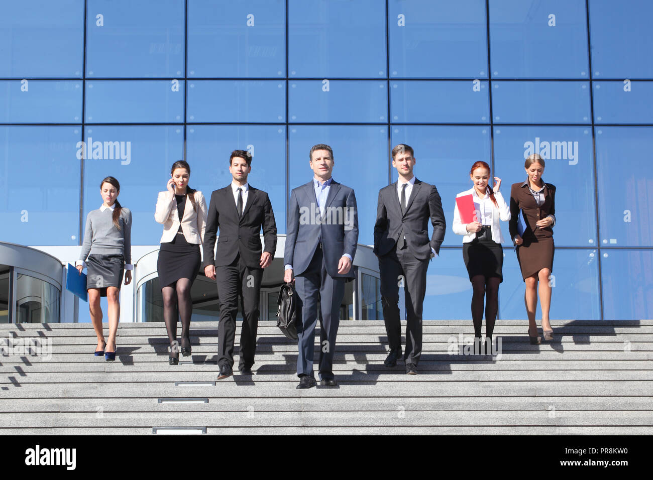 Team of diverse business people at stairs of company office building ...