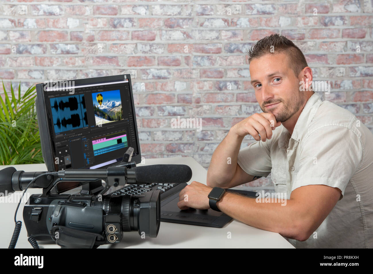 man video editor with computer and a professional video camera Stock ...