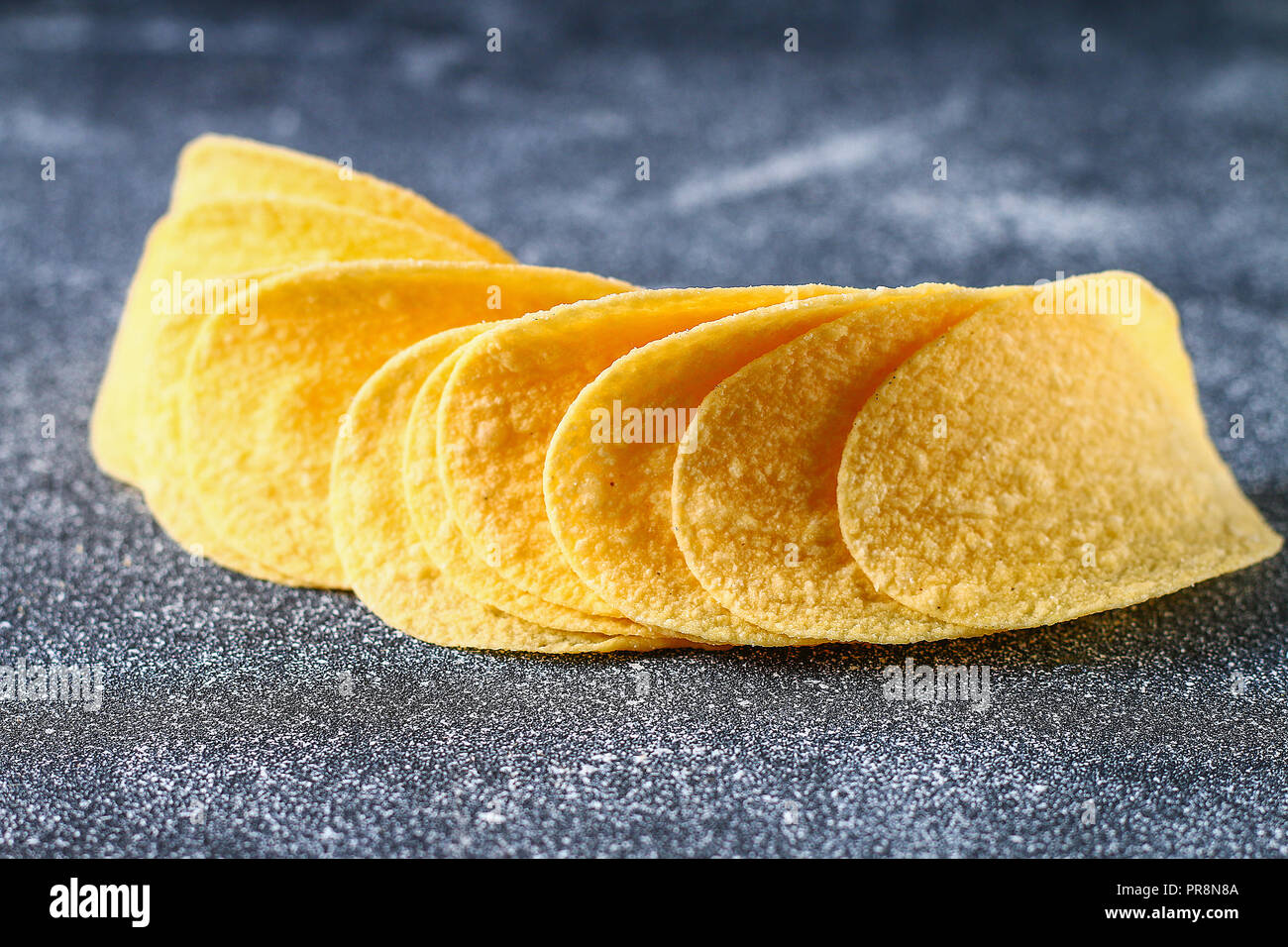 A stack of crispy chips on a gray dark table. Snack Stock Photo - Alamy