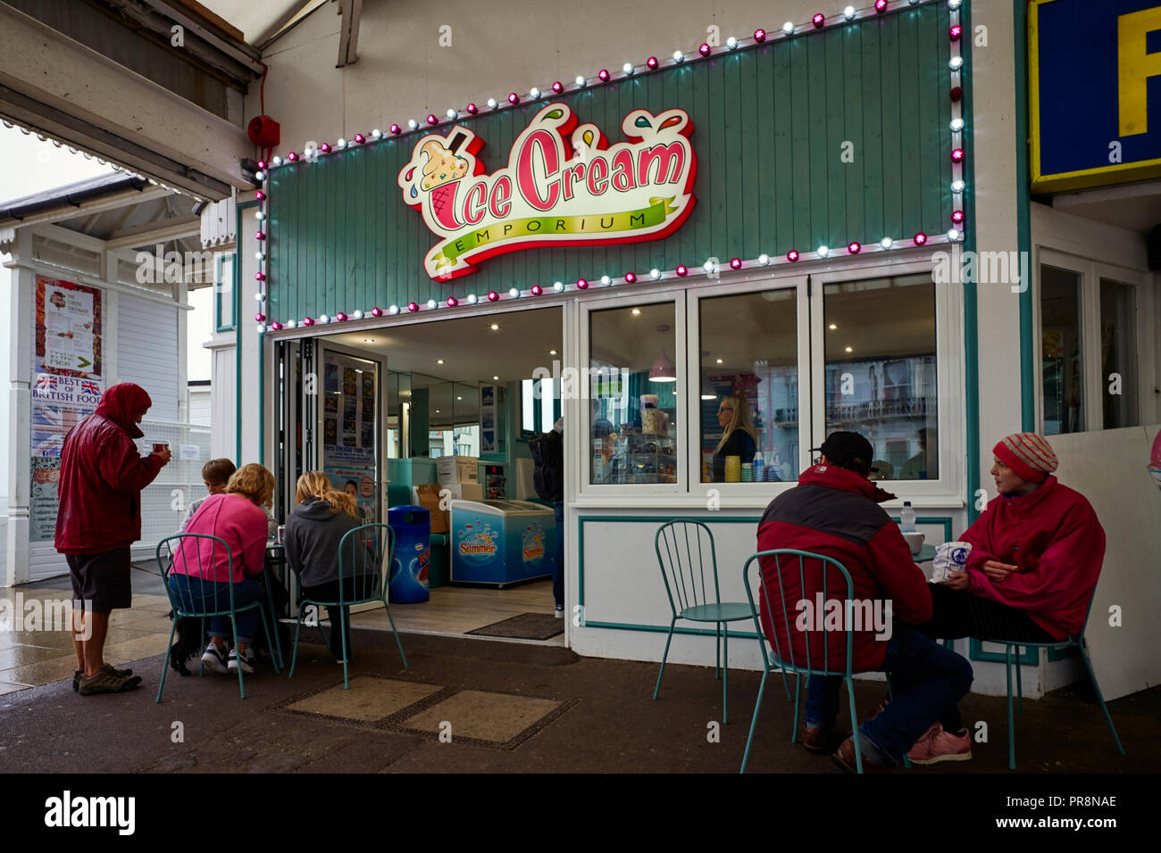 Ice cream parlour with people sitting outside on a pouring wet day at ...