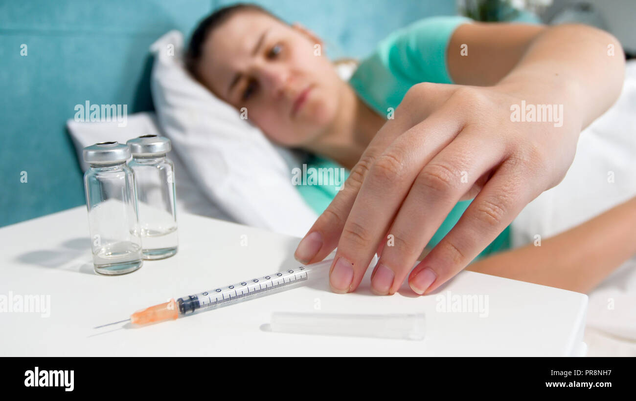Closeup photo of young sick woman holding syringe with medicines Stock ...