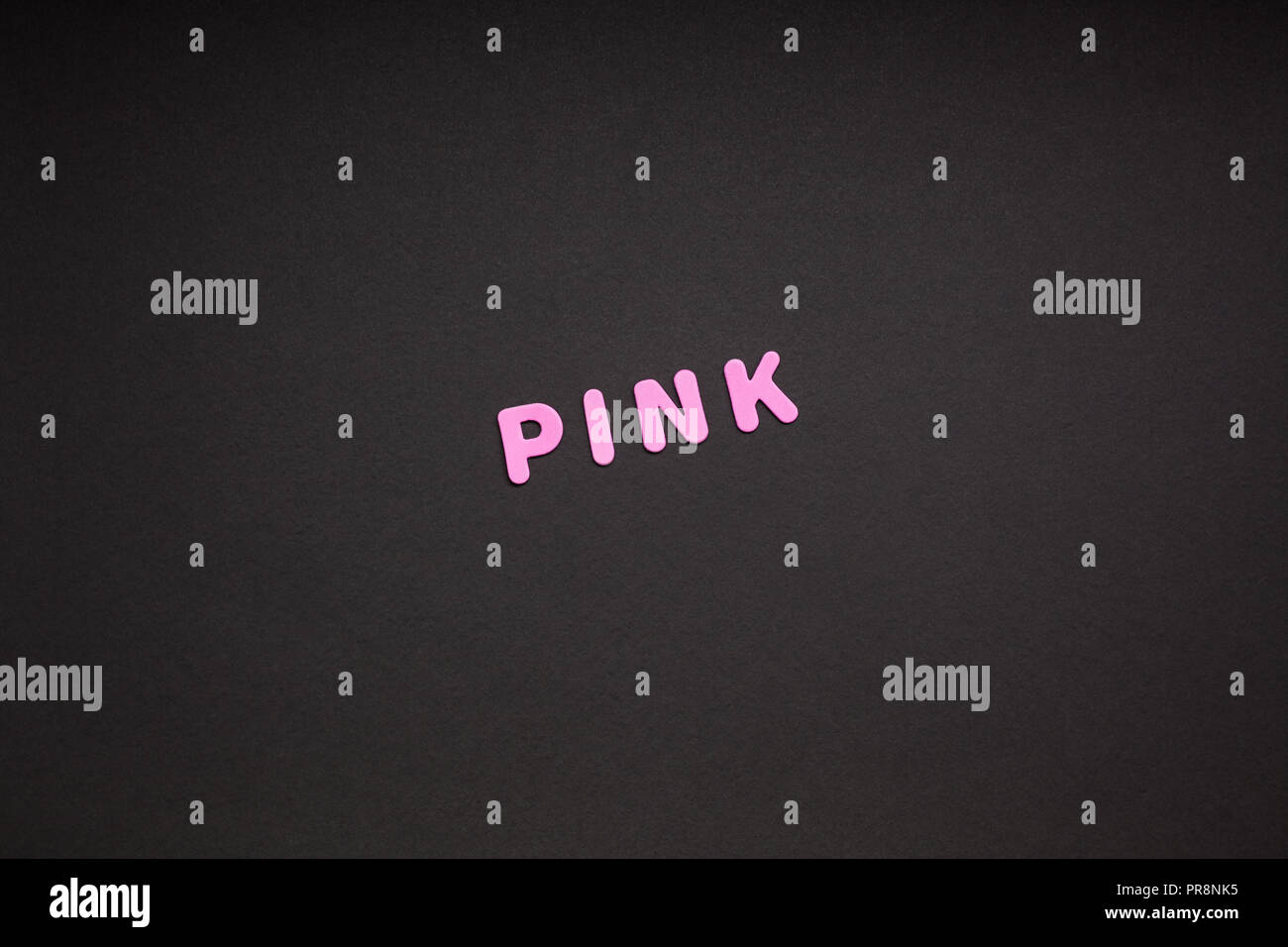 Creative colorful text made from plastic letters pink writing on black ...