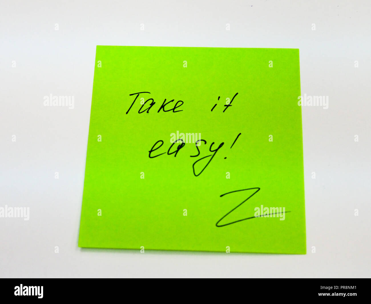 Sticky note with text take it easy Stock Photo - Alamy