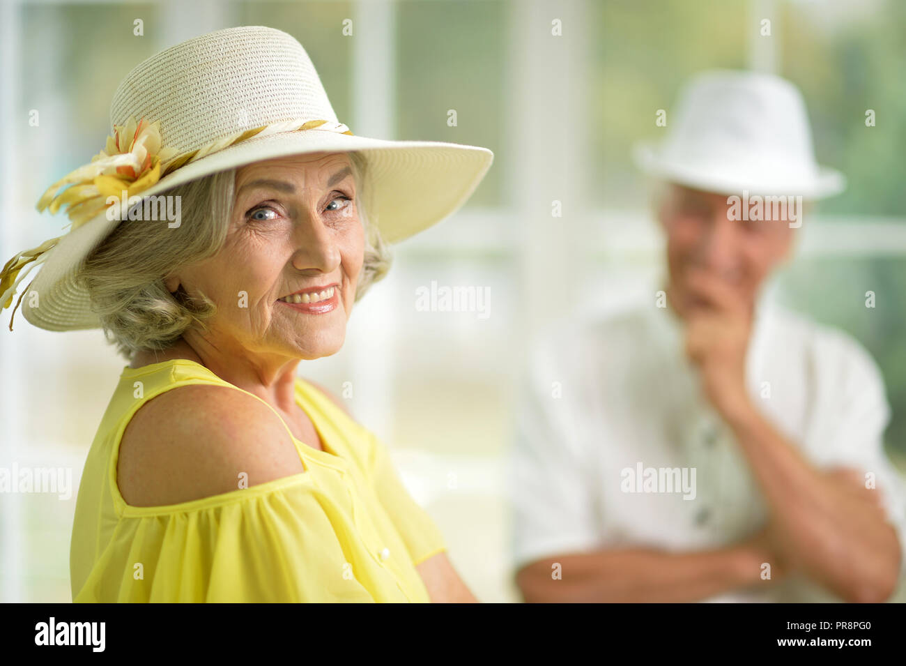 Elderly woman in yellow hat hi-res stock photography and images - Alamy