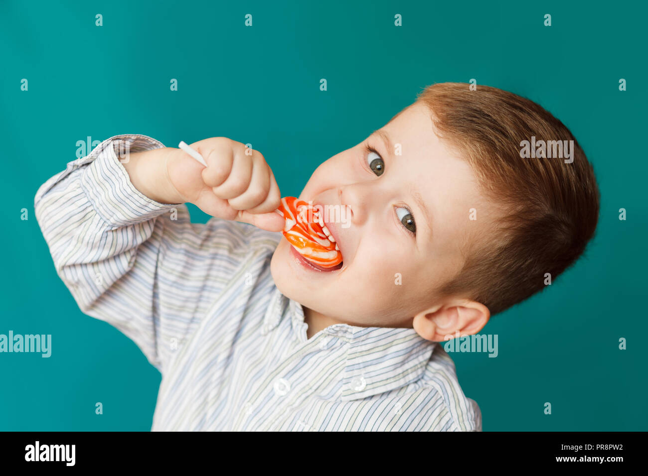 Happy child eating sweets. Child boy eating lollipop isolated Stock ...