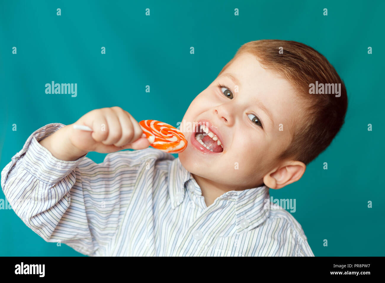 Happy child eating sweets. Child boy eating lollipop isolated Stock ...