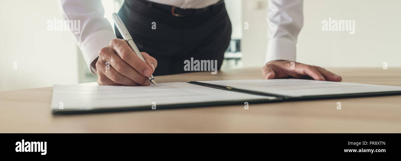 Businessman signing contract, document or report in a binder while ...