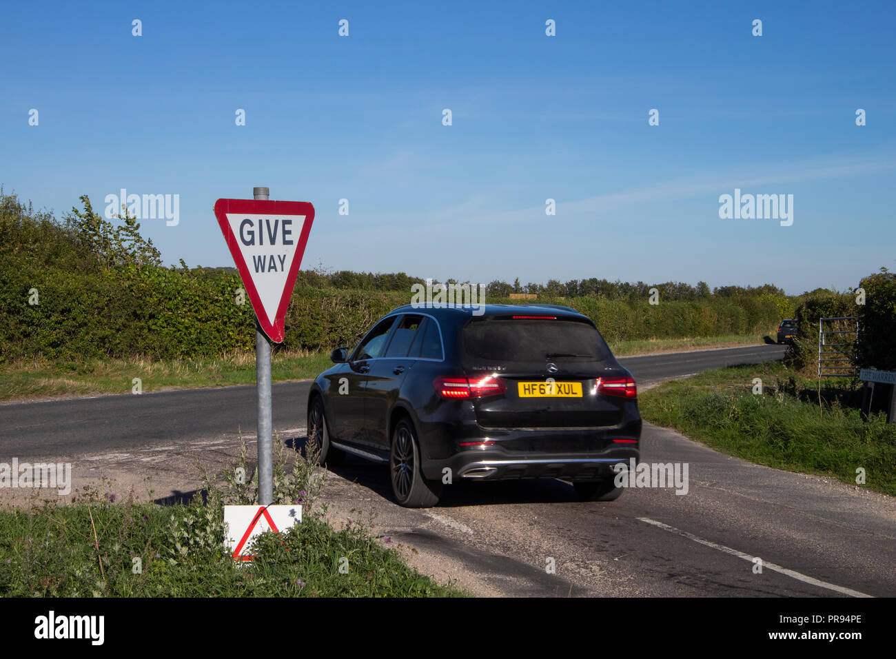 give way road sign on country lane joining main highway junction in ...