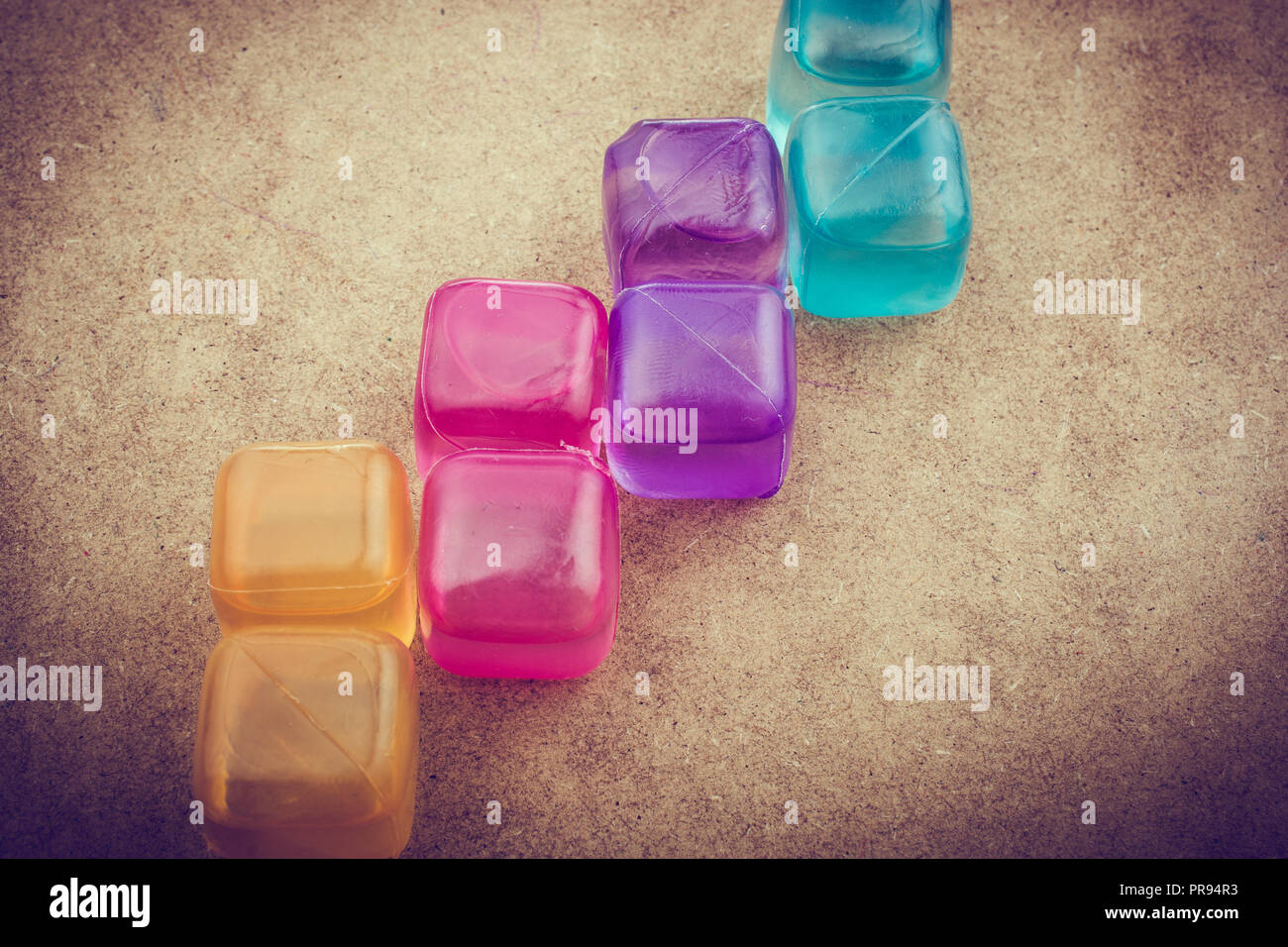 Fake colorful ice cubes on a brown background Stock Photo - Alamy