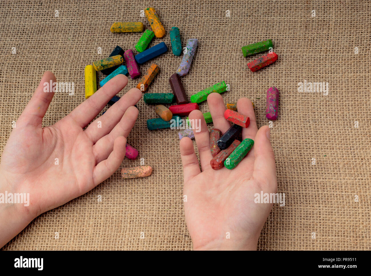 Used color crayons and a hand holding some Stock Photo - Alamy