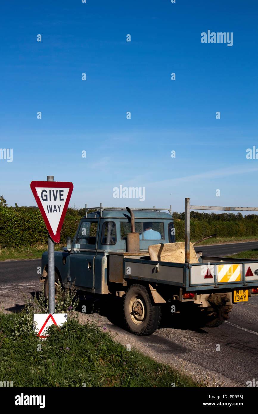 give way road sign on country lane joining main highway junction in ...