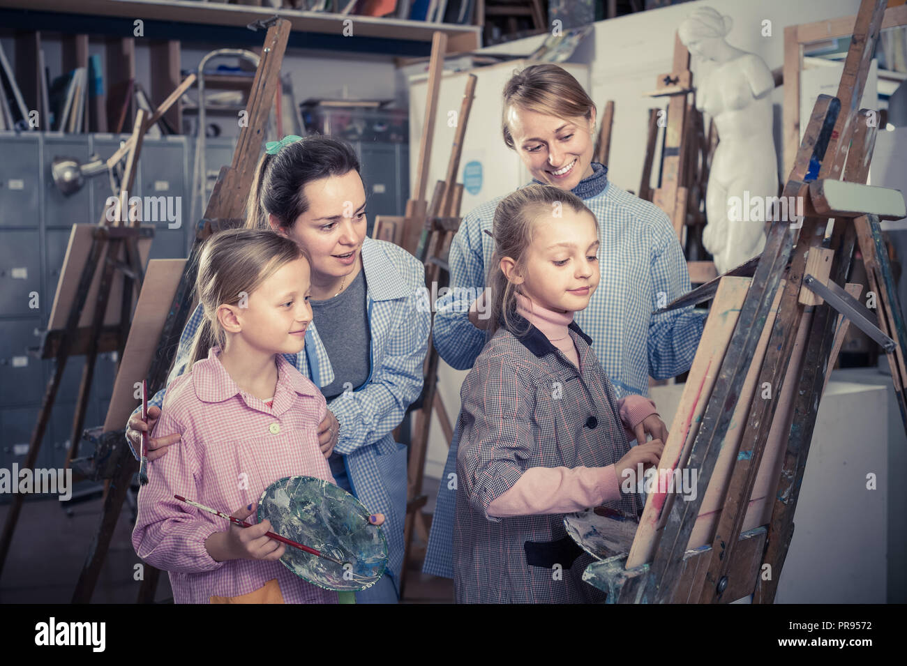 Young female students appraising work of their group mate during class ...