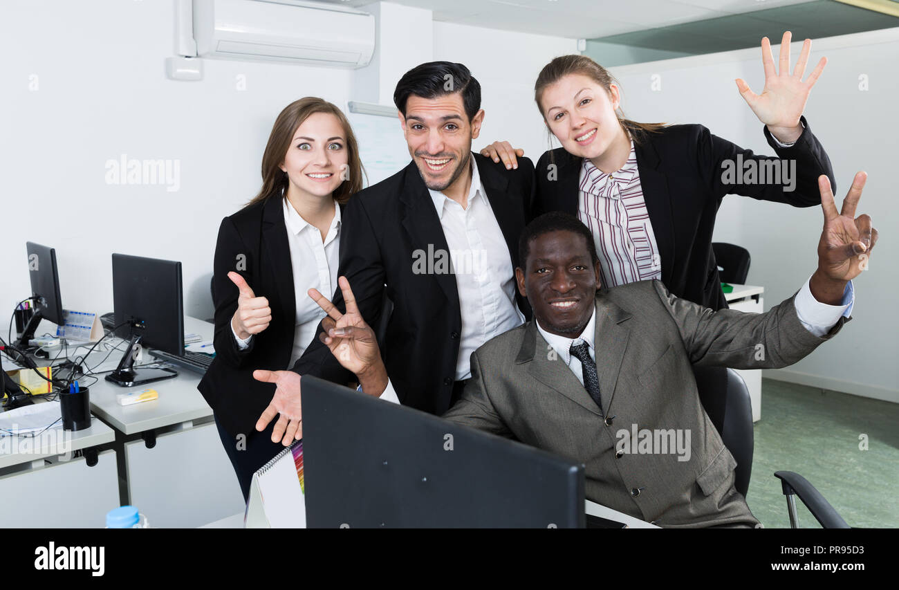 Smiling multinational business group expressing satisfaction with ...