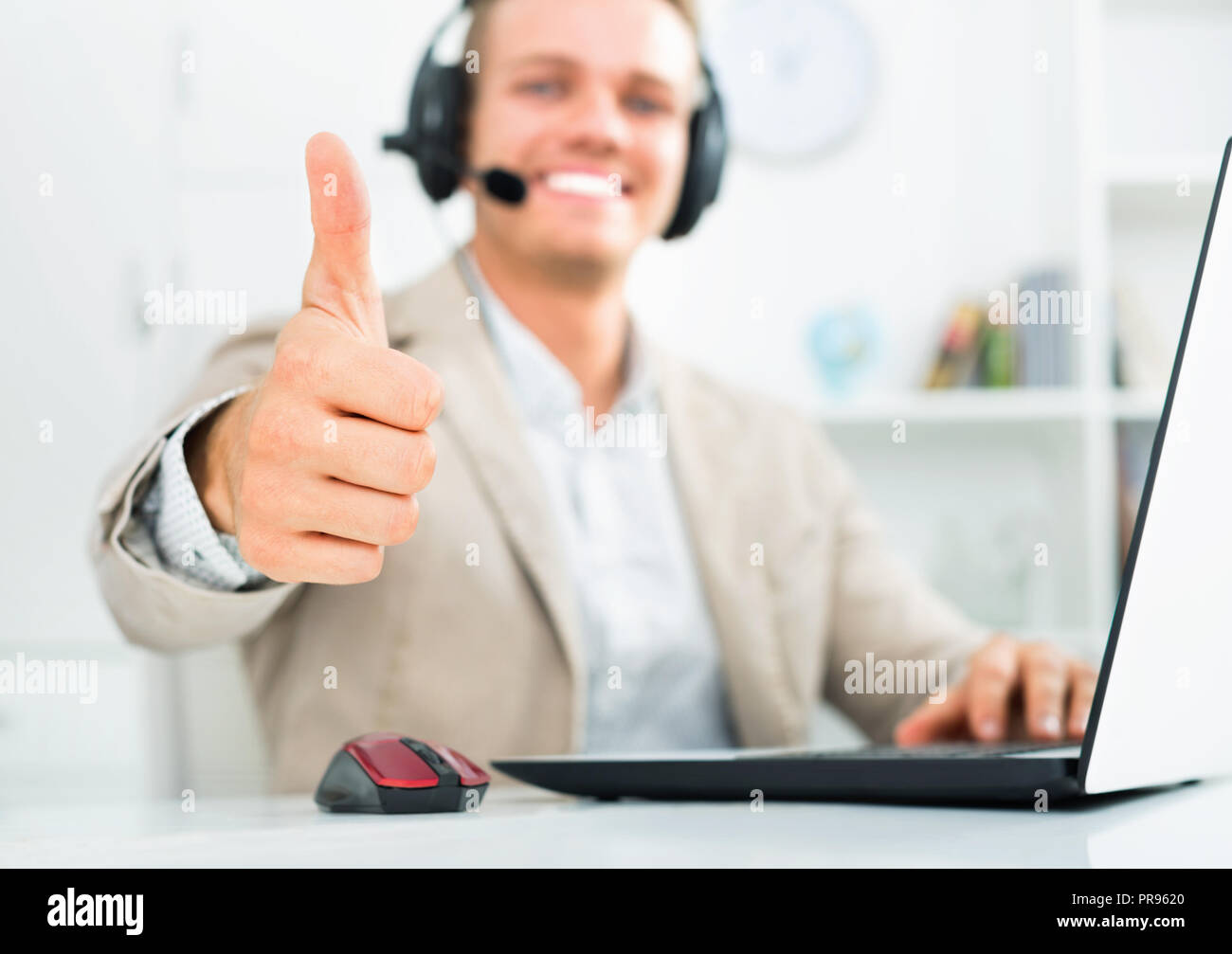 Friendly happy call center male operator talking with client in agency ...