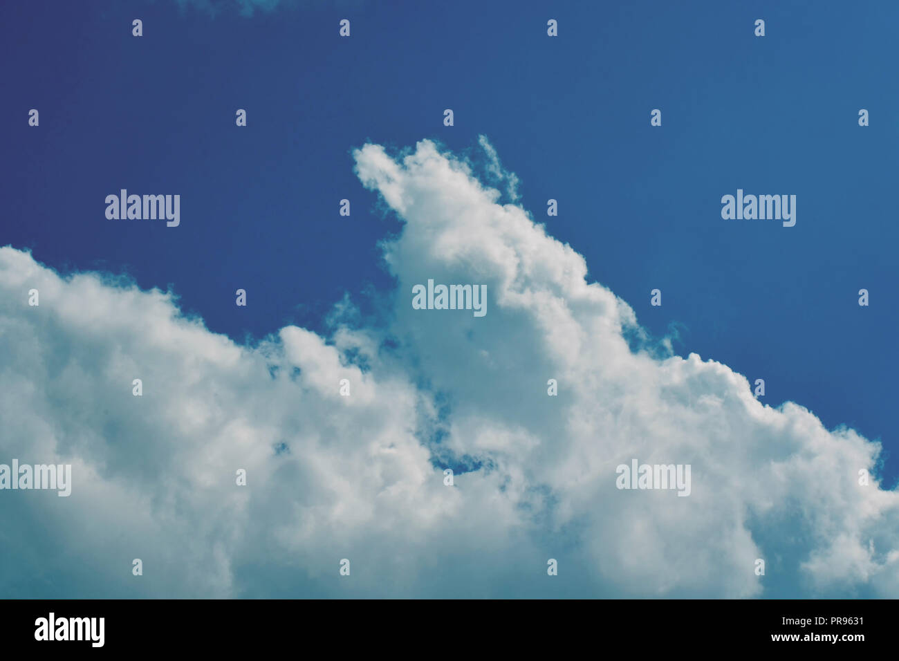 Nature background. Fluffy soft clouds in sky toned Stock Photo - Alamy