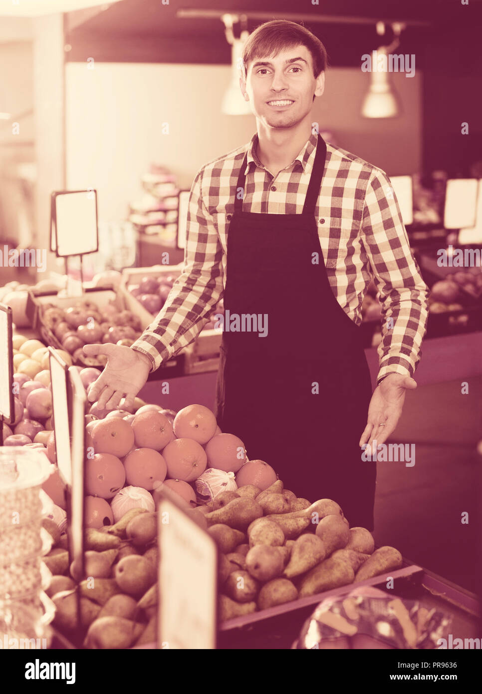 Grocery worker selling seasonal fruits in farm food store Stock Photo ...