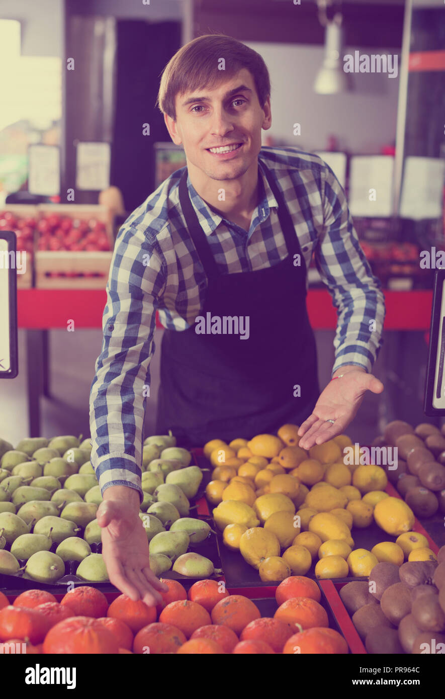 Portrait of young man 35s offering fruits in grocery and smiling Stock ...