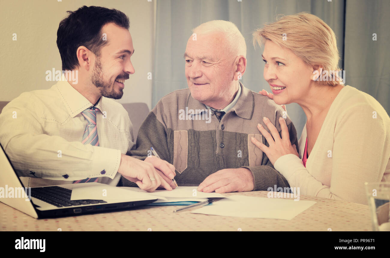 Mature woman and her eldery father studying agreement conditions with ...