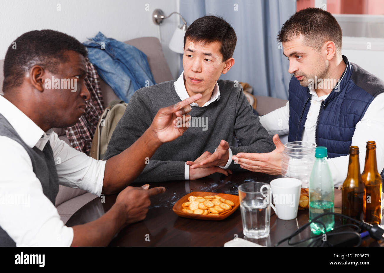 Three serious friends are talking about life together at home Stock ...