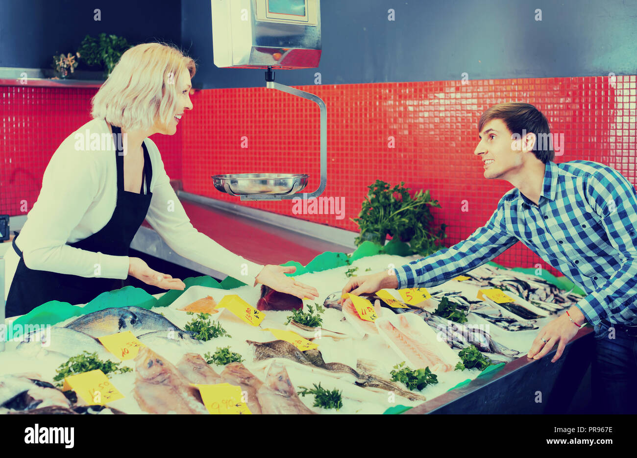 Ordinary male customer choosing and buying fish at market Stock Photo ...
