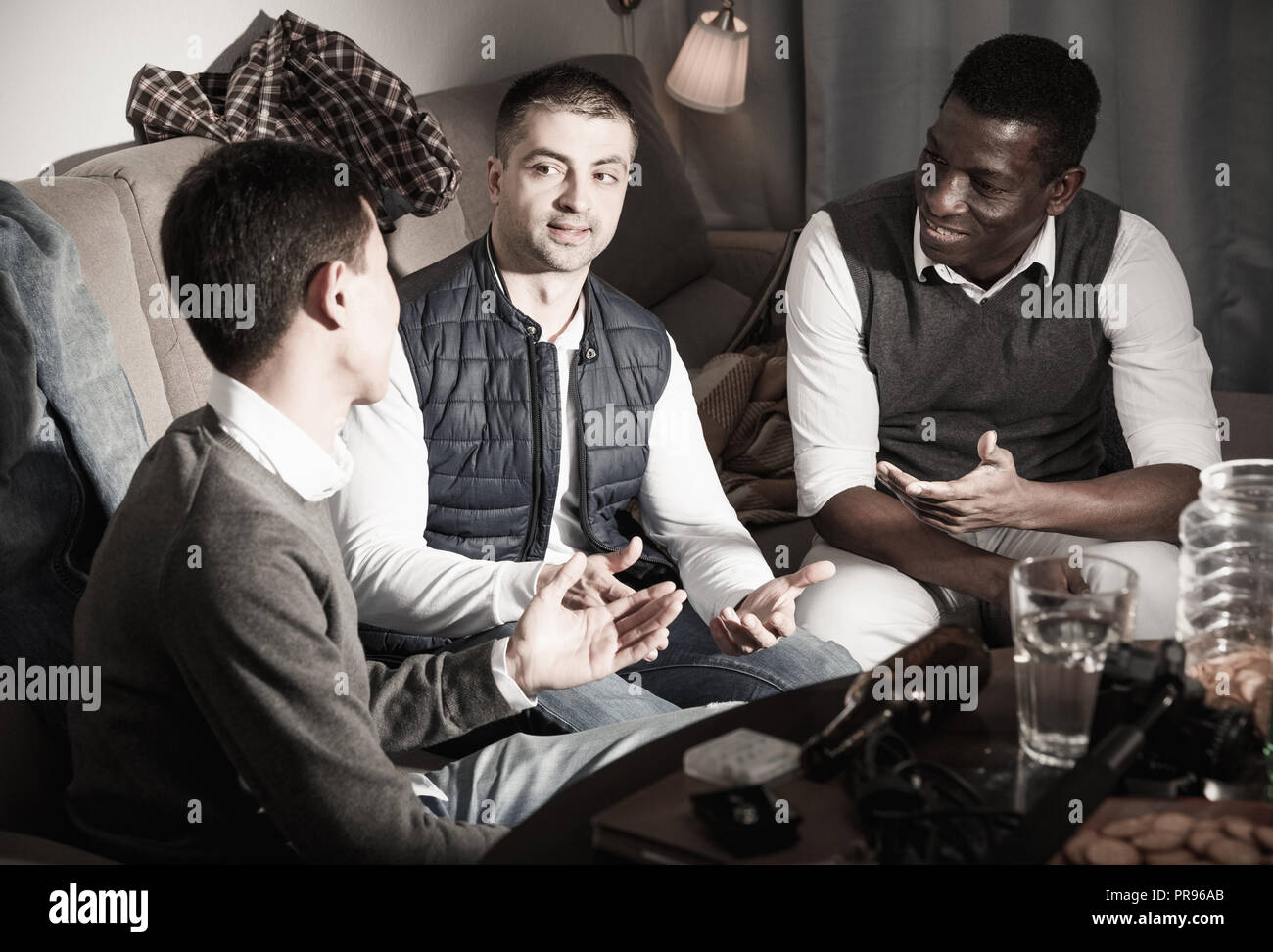 Happy multinational friends talking table hi-res stock photography and ...