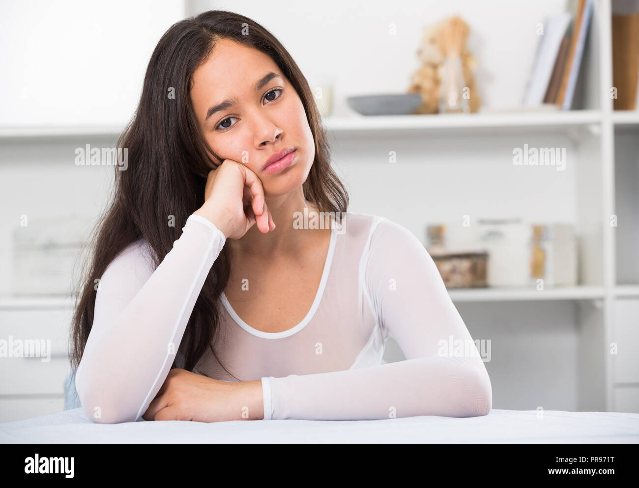 Young sad woman sitting at the table and melancholy at home Stock Photo ...