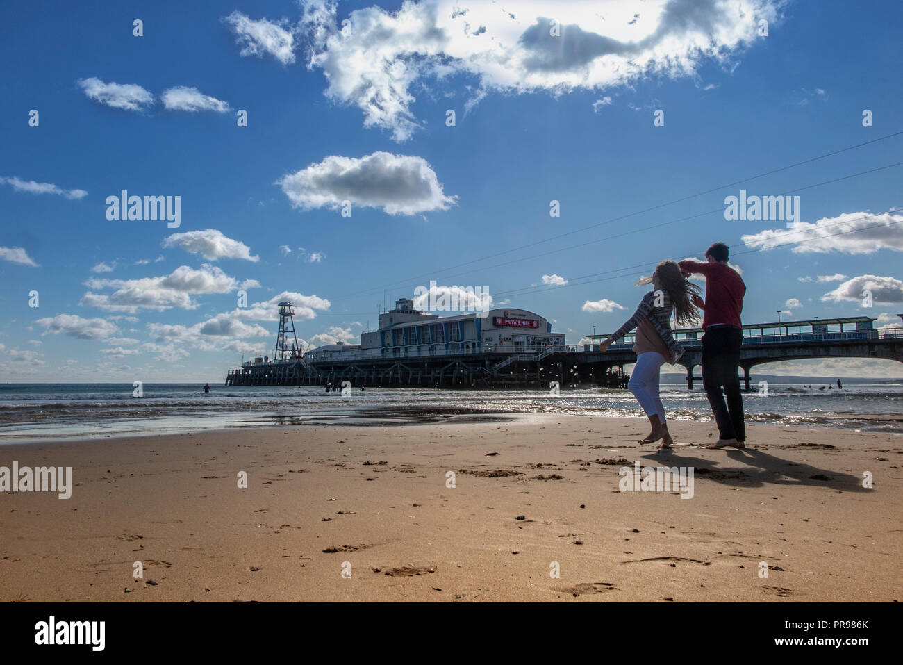 A couple dane on the beach in Bournemouth with the pier as a backdrop ...