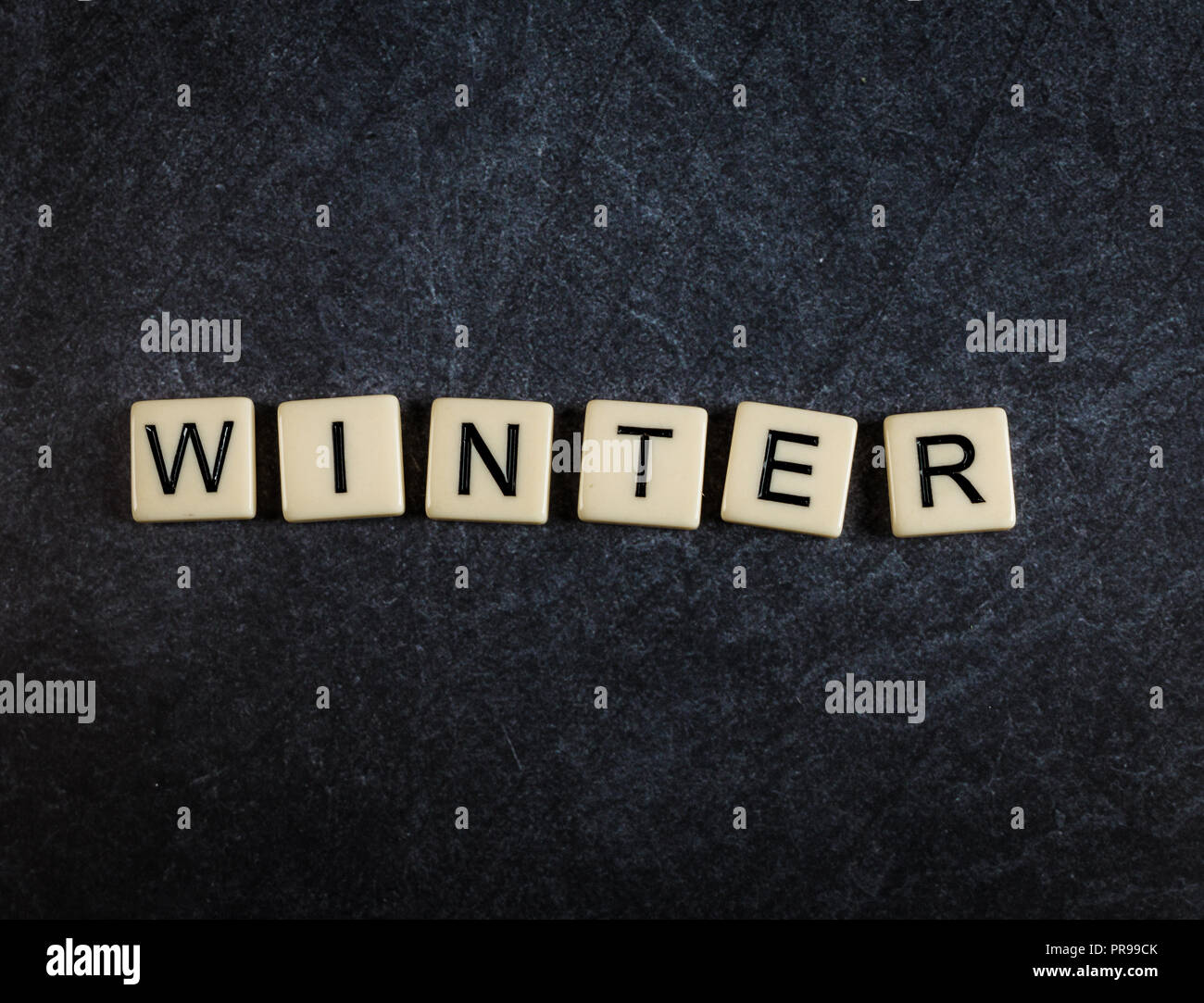 Scrabble letter tiles on black slate background spelling Winter Stock ...
