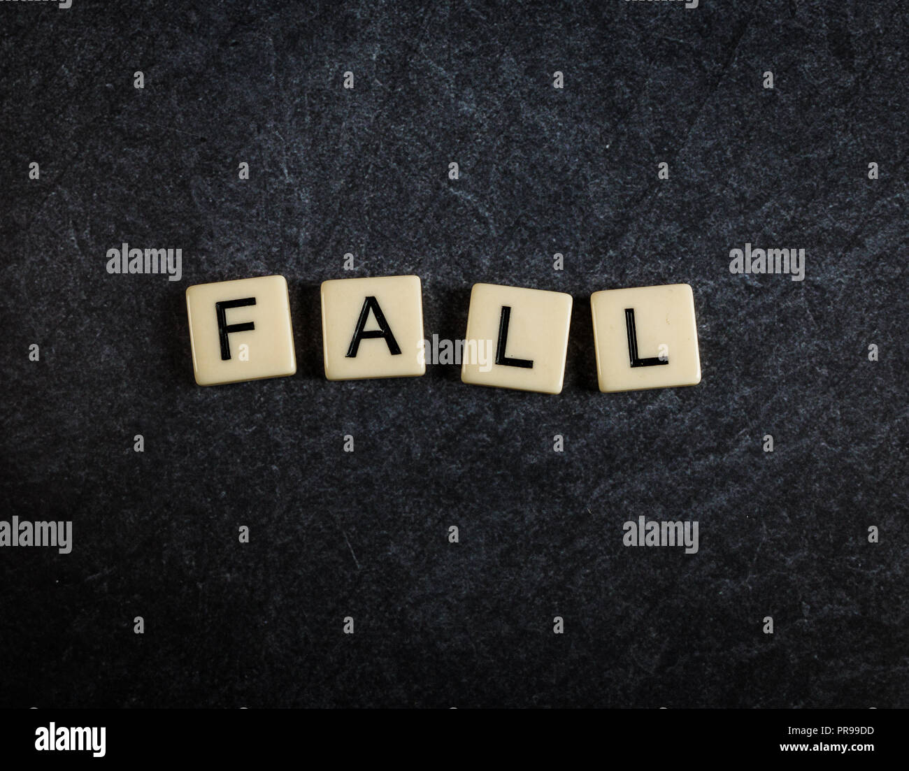 Scrabble letter tiles on black slate background spelling Fall Stock ...