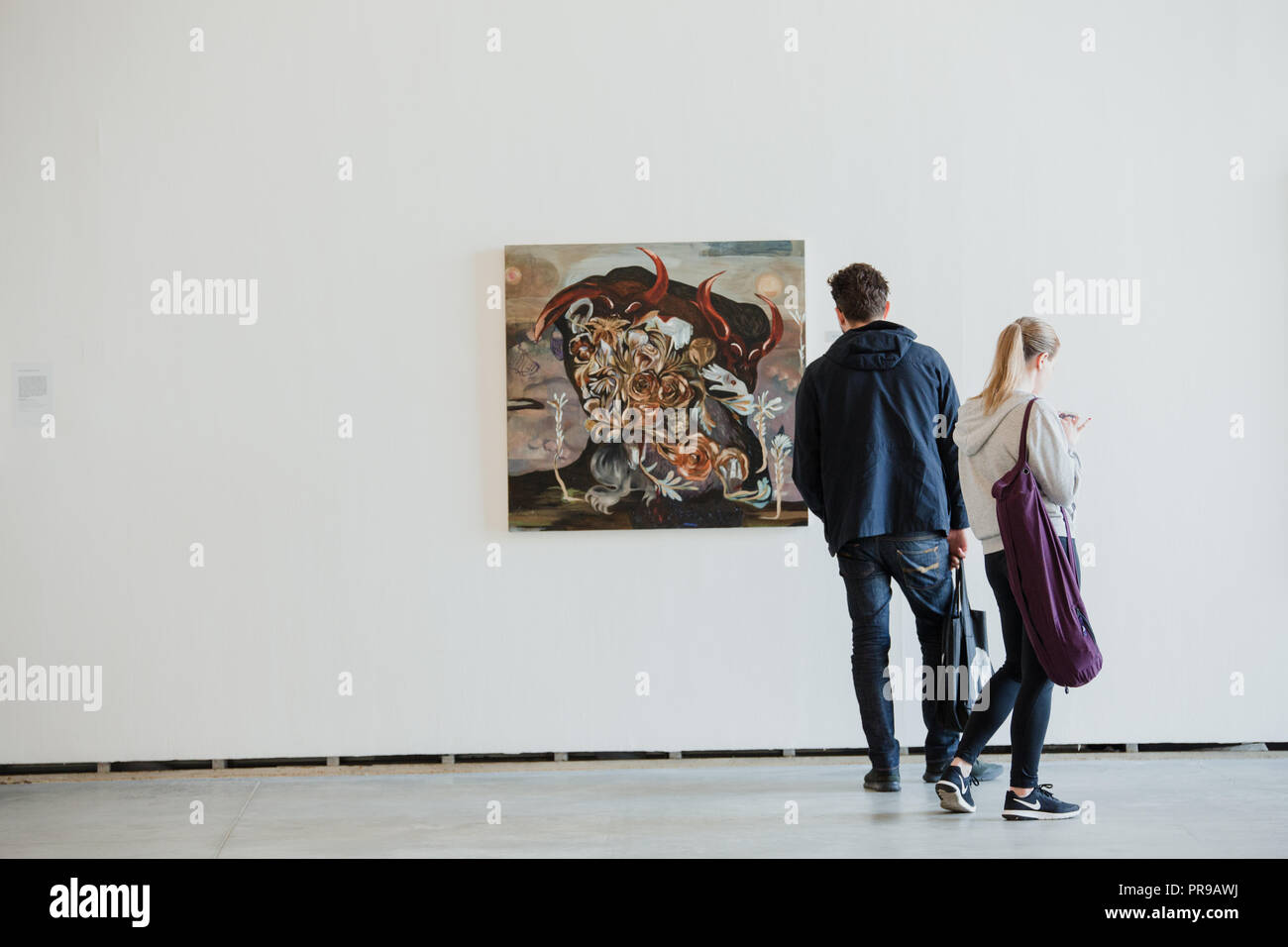 man looking at painting woman walking away Stock Photo - Alamy