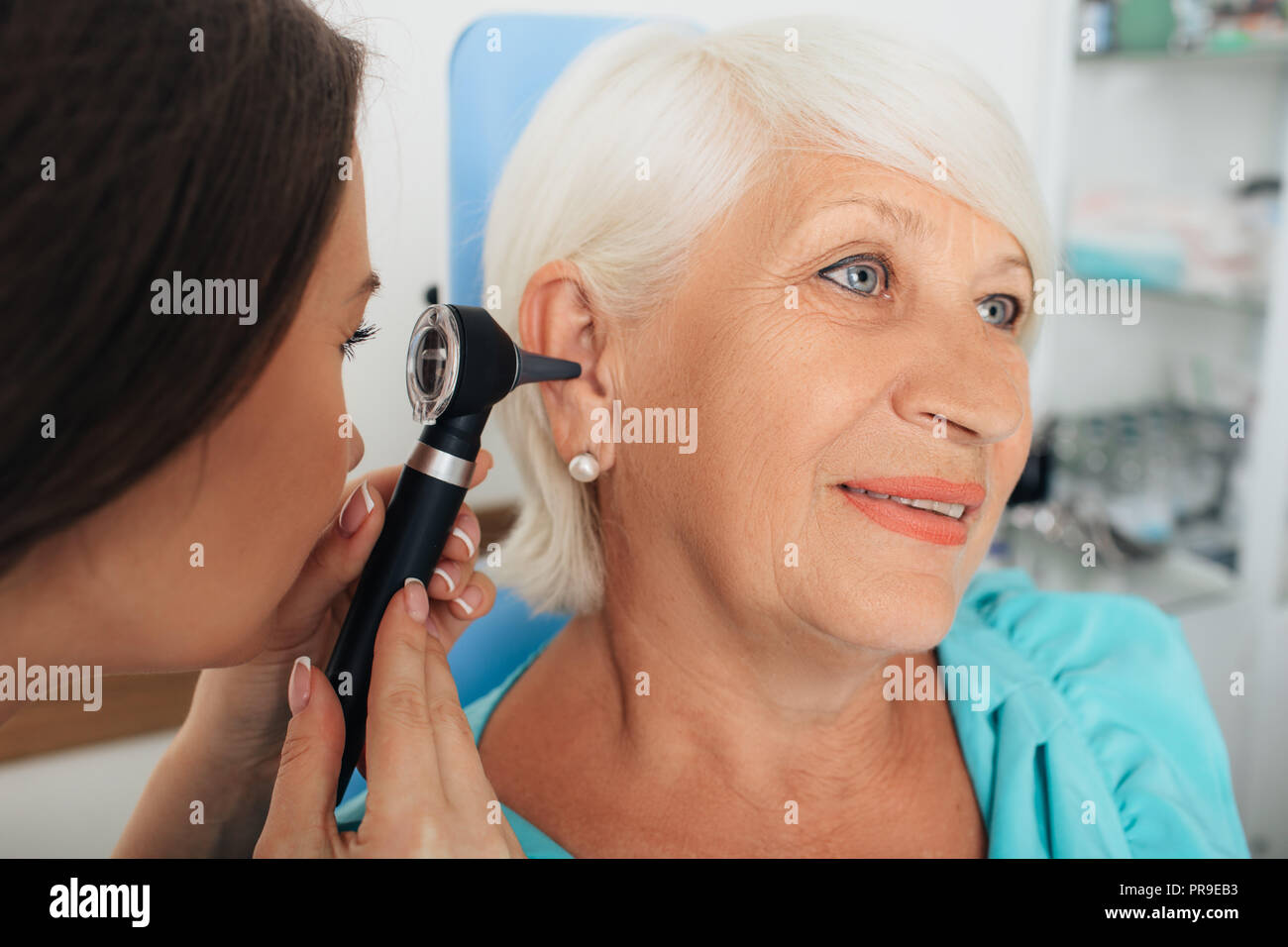 Mature woman getting ear exam at clinic Stock Photo - Alamy