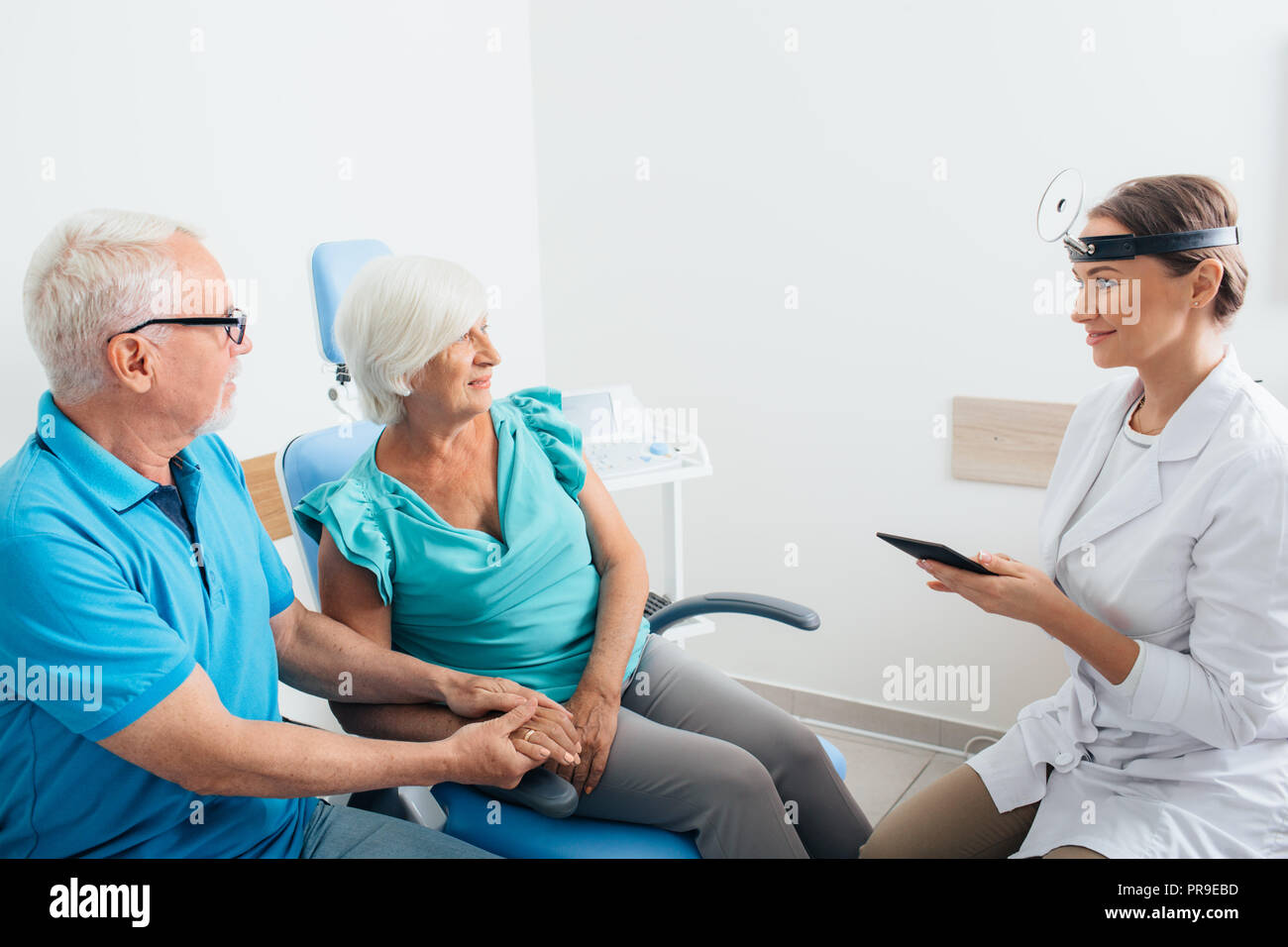 ENT Doctor talking with senior patients in doctors office Stock Photo ...
