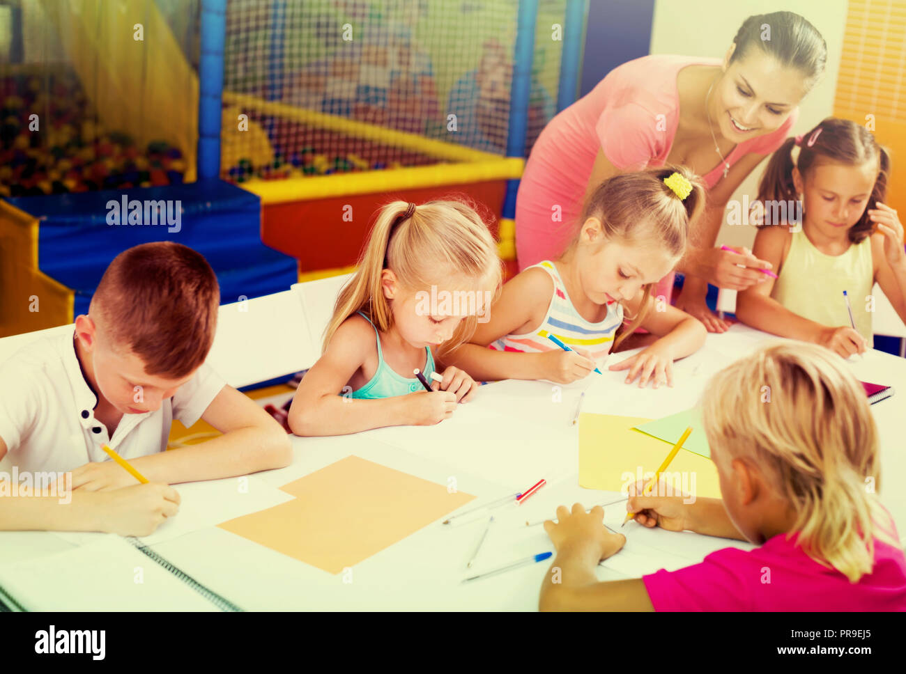 Positive children drawing on lesson in elementary education class with ...
