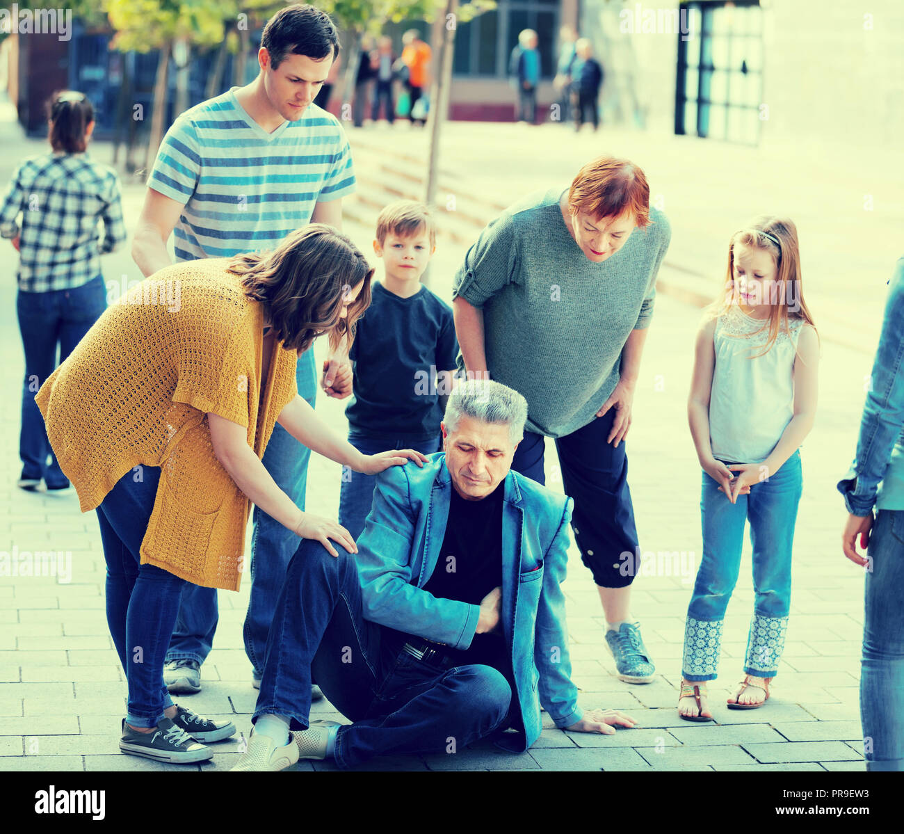 People of different ages helping mature man with pain in heart Stock ...