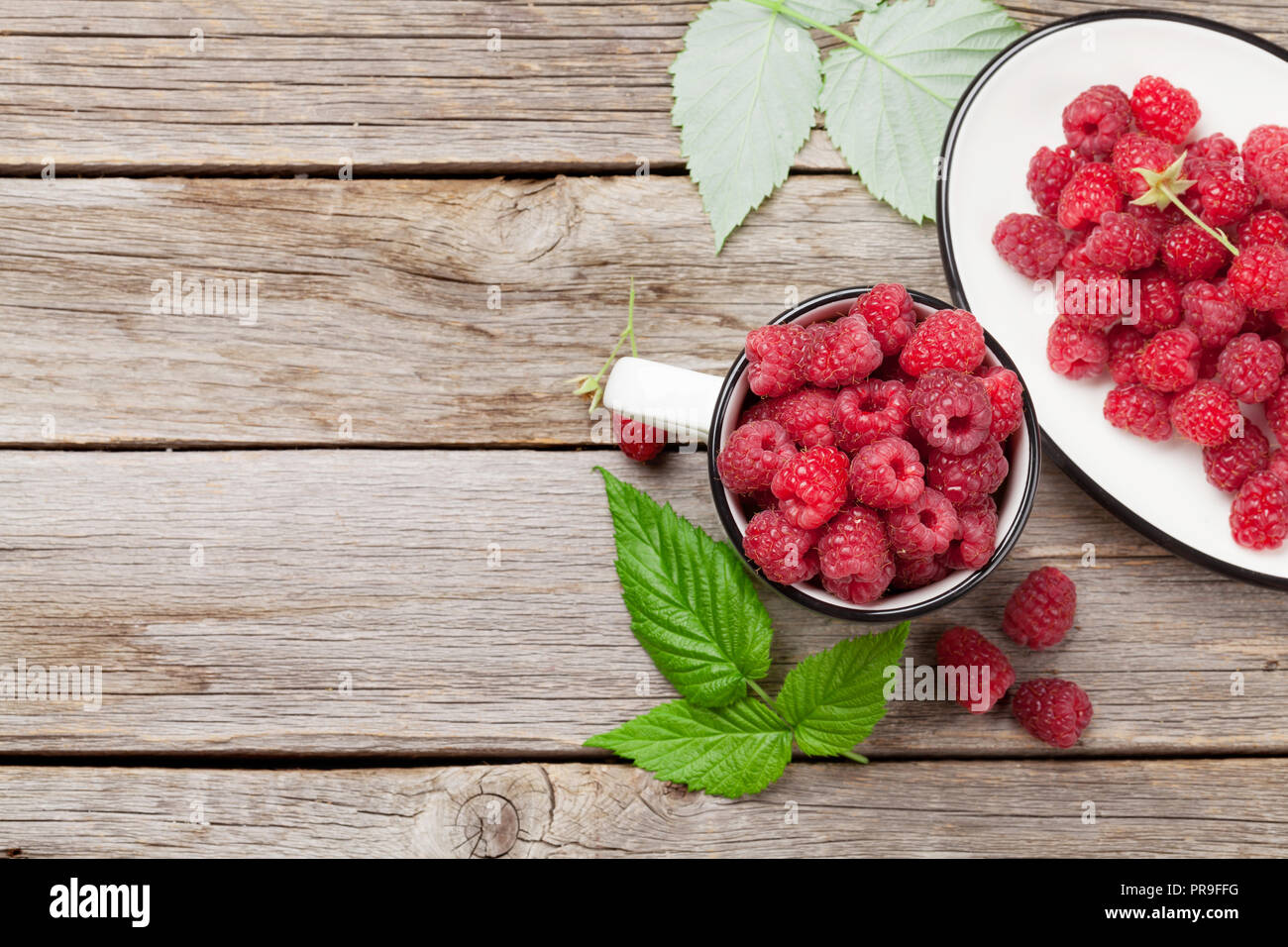 Cup of ripe raspberries on wooden table. Top view with space for your ...