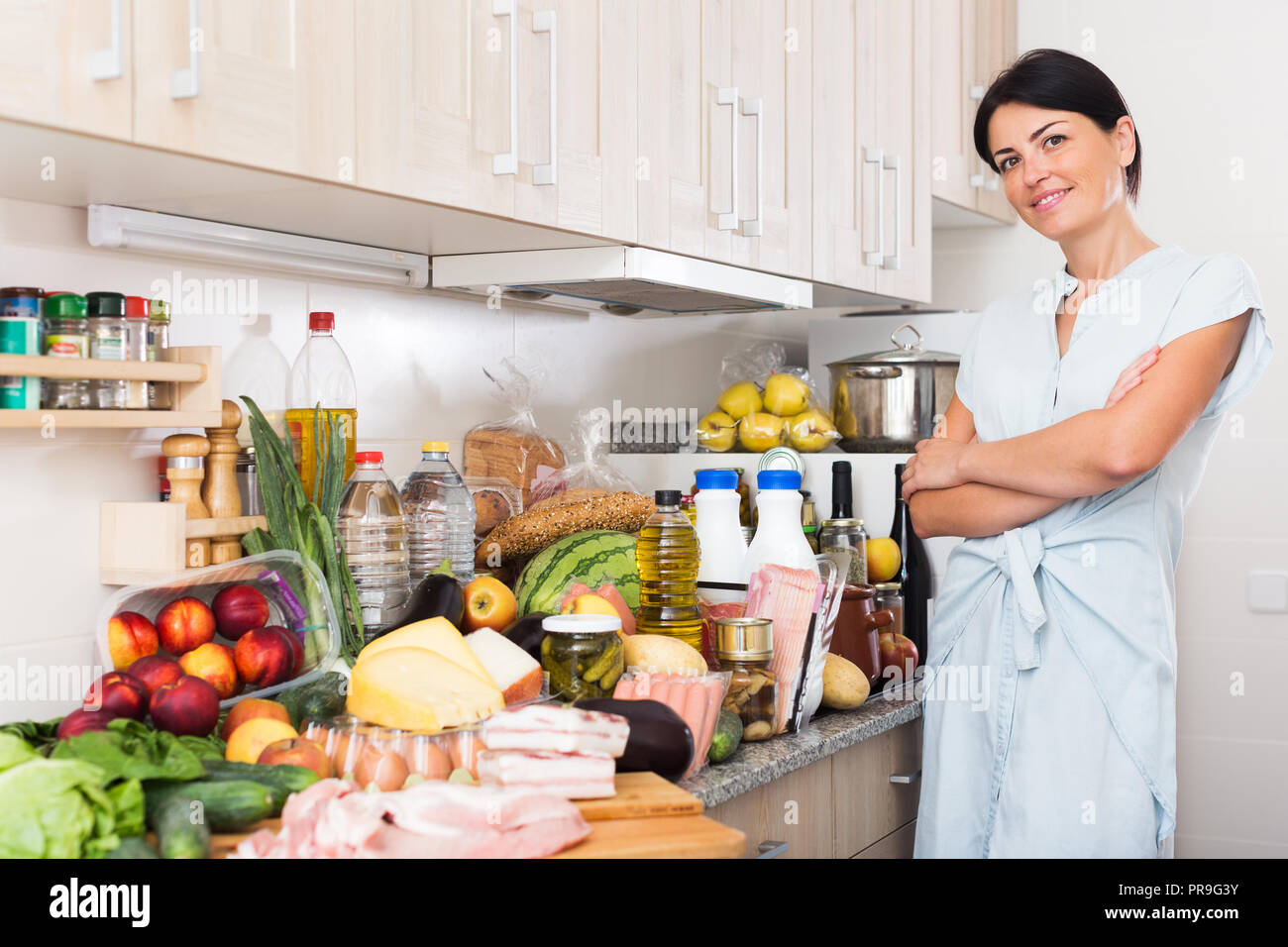 brunette female is posing in time cooking on the kitchen at home Stock ...