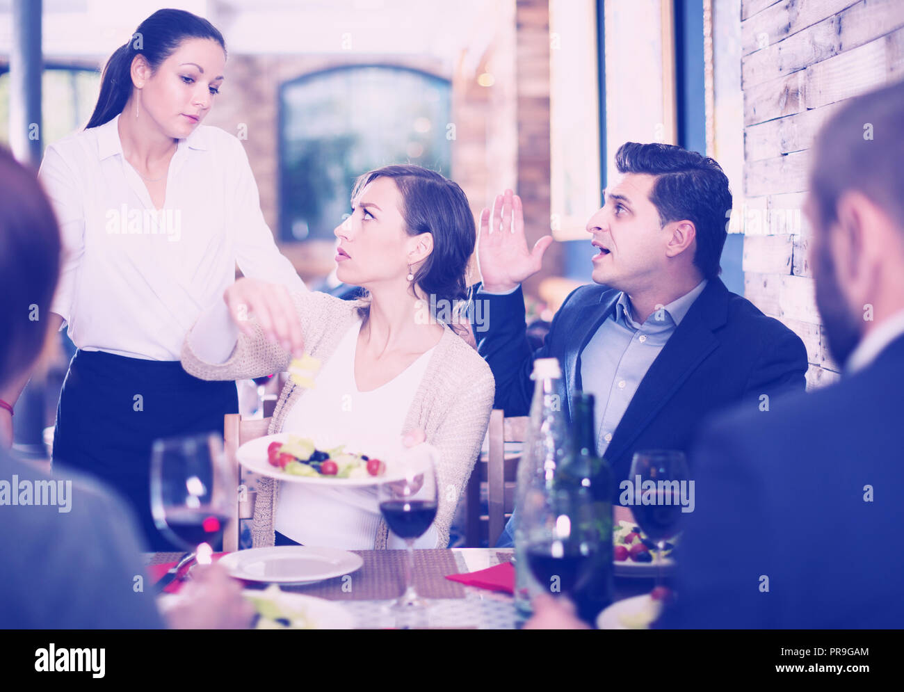 Angry female and male visitors conflict with apologetic waitress about ...