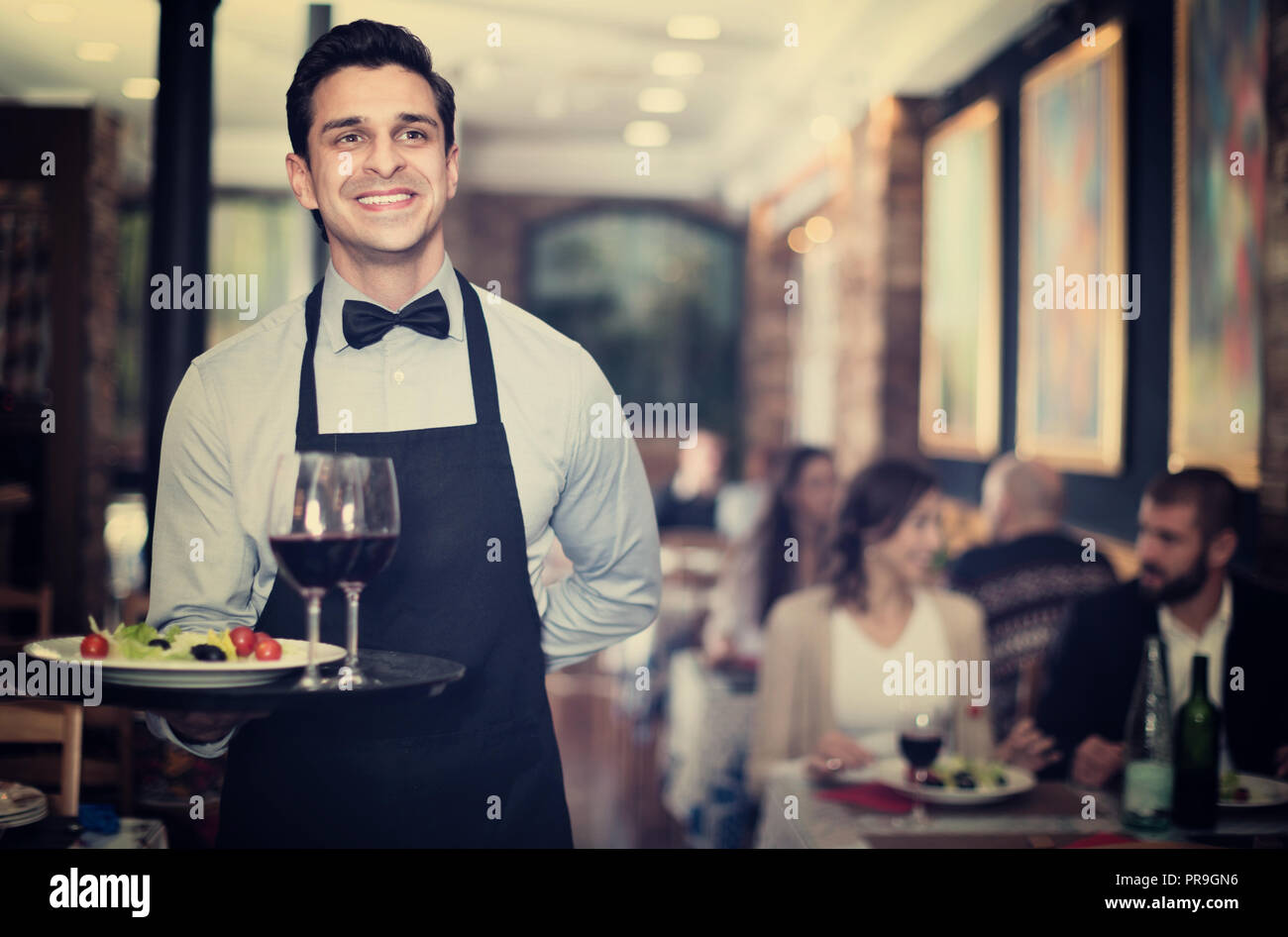 Professional pleasant waiter holding hi-res stock photography and ...