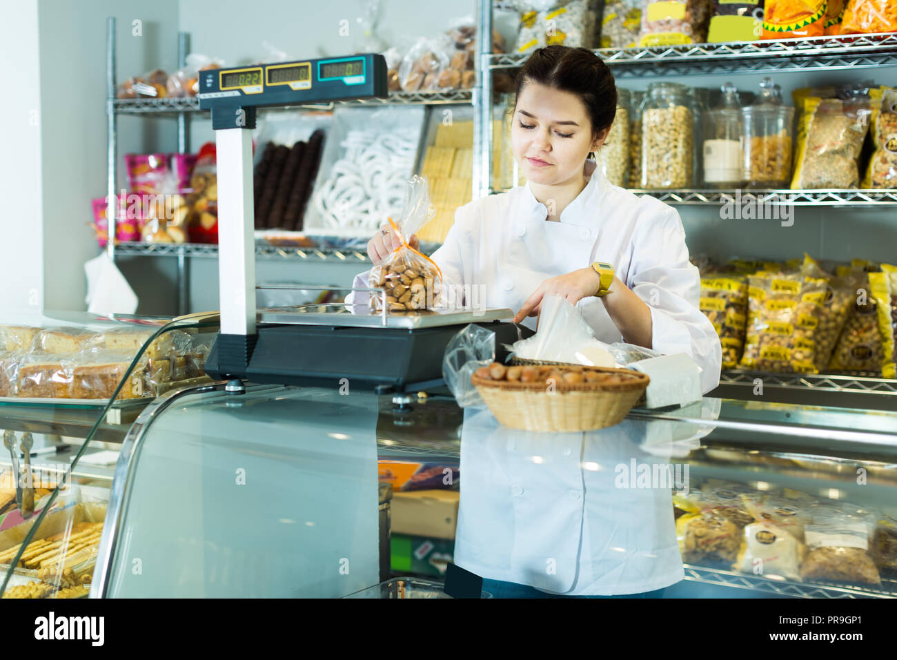 Girl vendor sells cookies in a candy store Stock Photo - Alamy