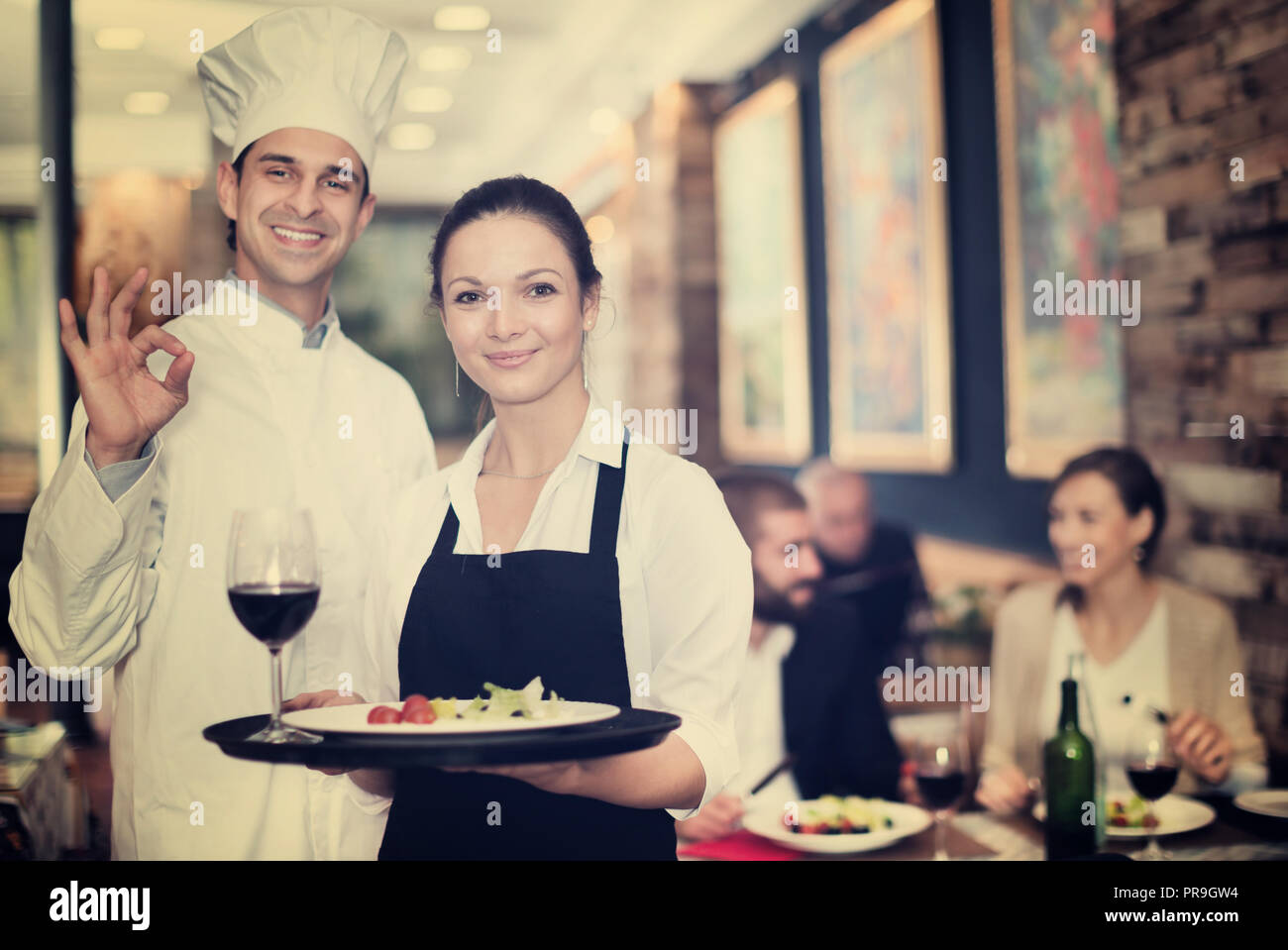 Portrait of smiling waitress with professional chef at the restaurant ...