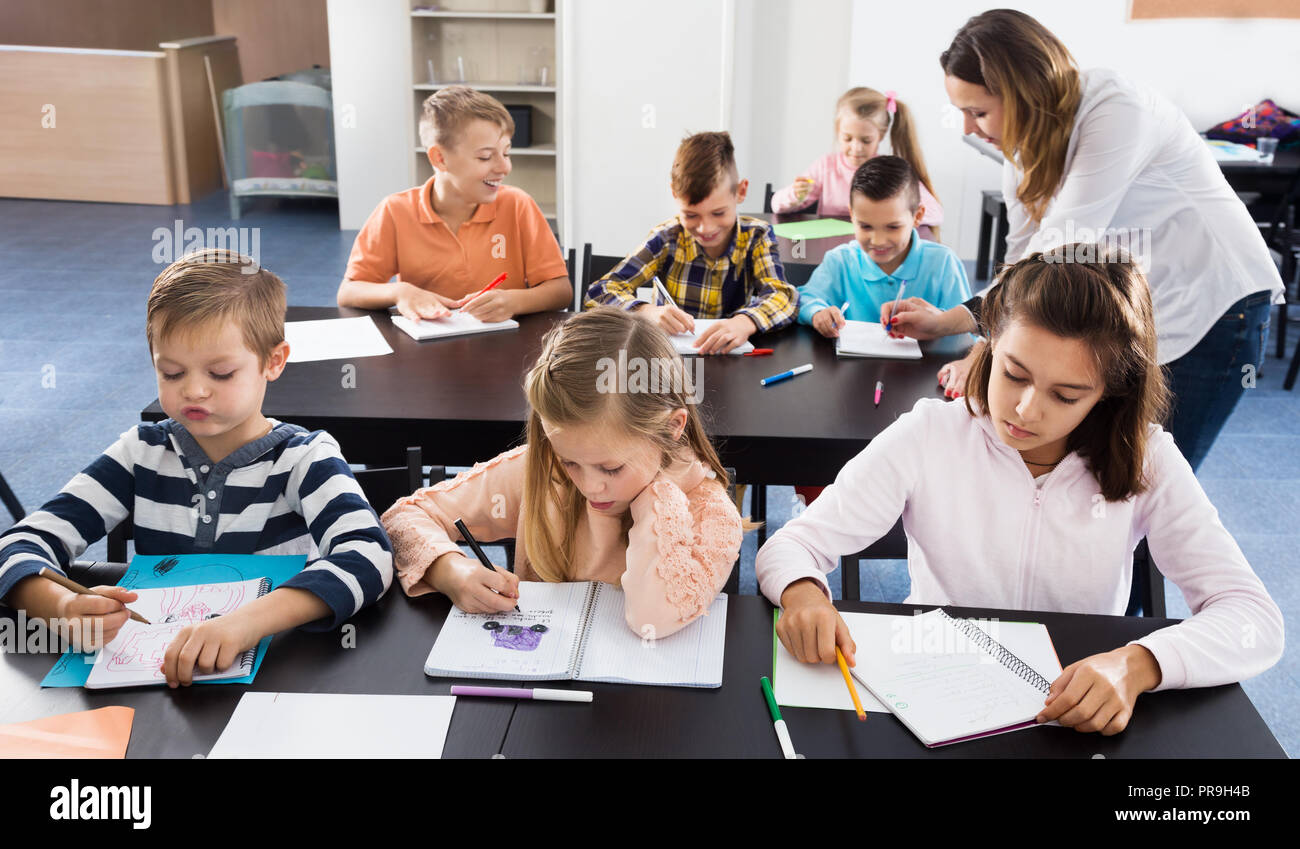 Professor and elementary age children at the classroom in a school ...
