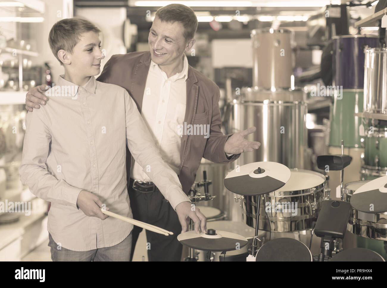 happy european father and teenage son examining drum units in guitar ...