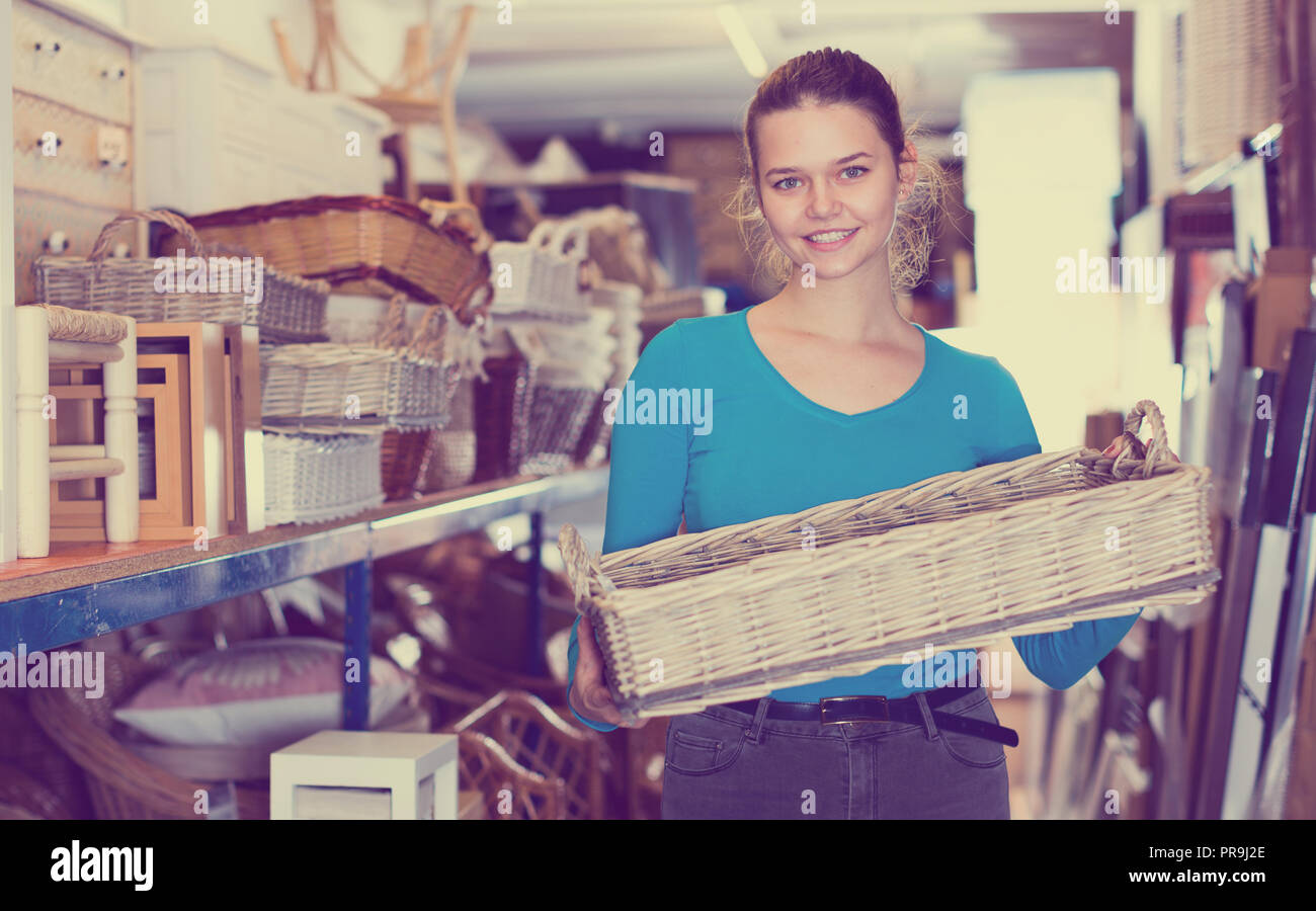 Young girl customer standing with wicker basket in shop for decor Stock ...